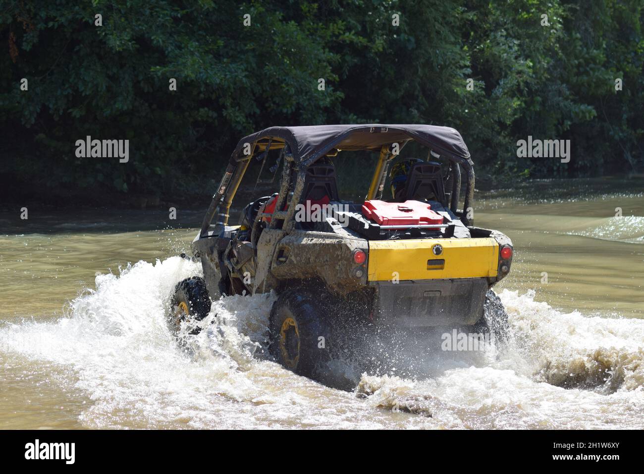 The man on the ATV crosses a stream. Tourist walks on a cross-country ...