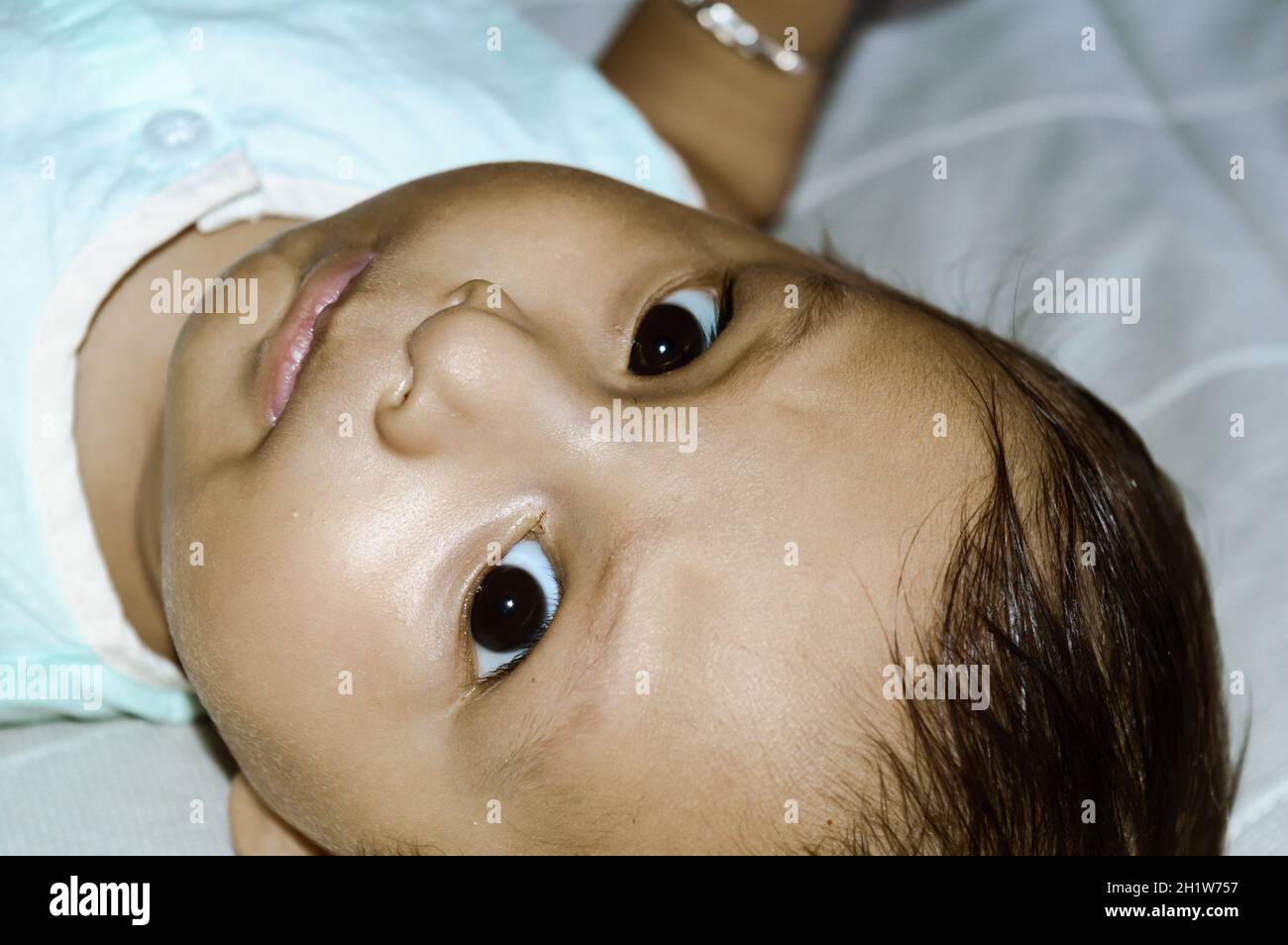 Close up face of cute newborn baby boy upside down and Looking at ...