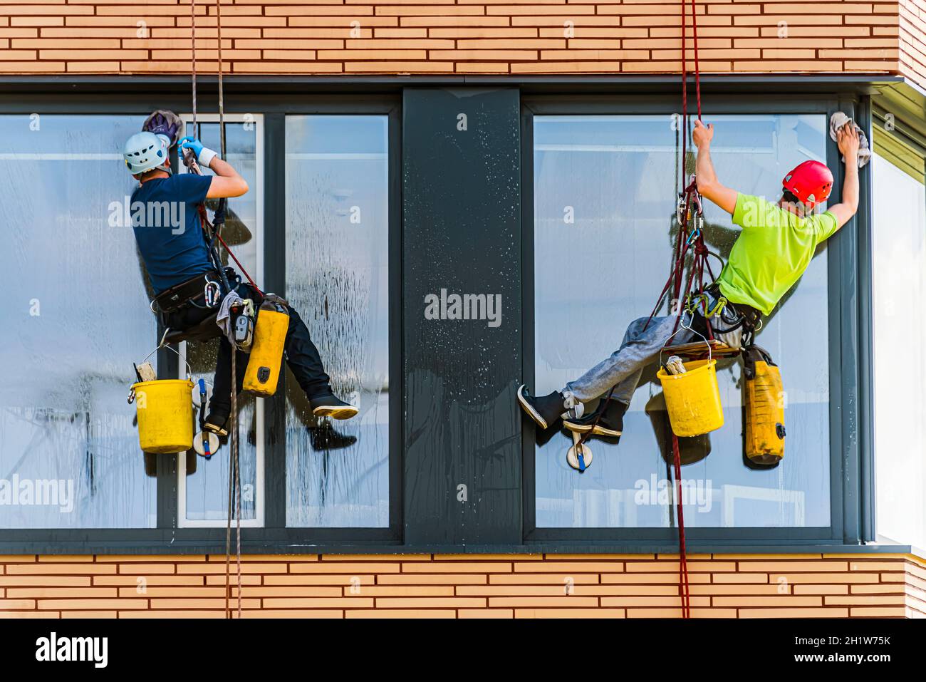 Two men cleaning windows on an office building Stock Photo - Alamy