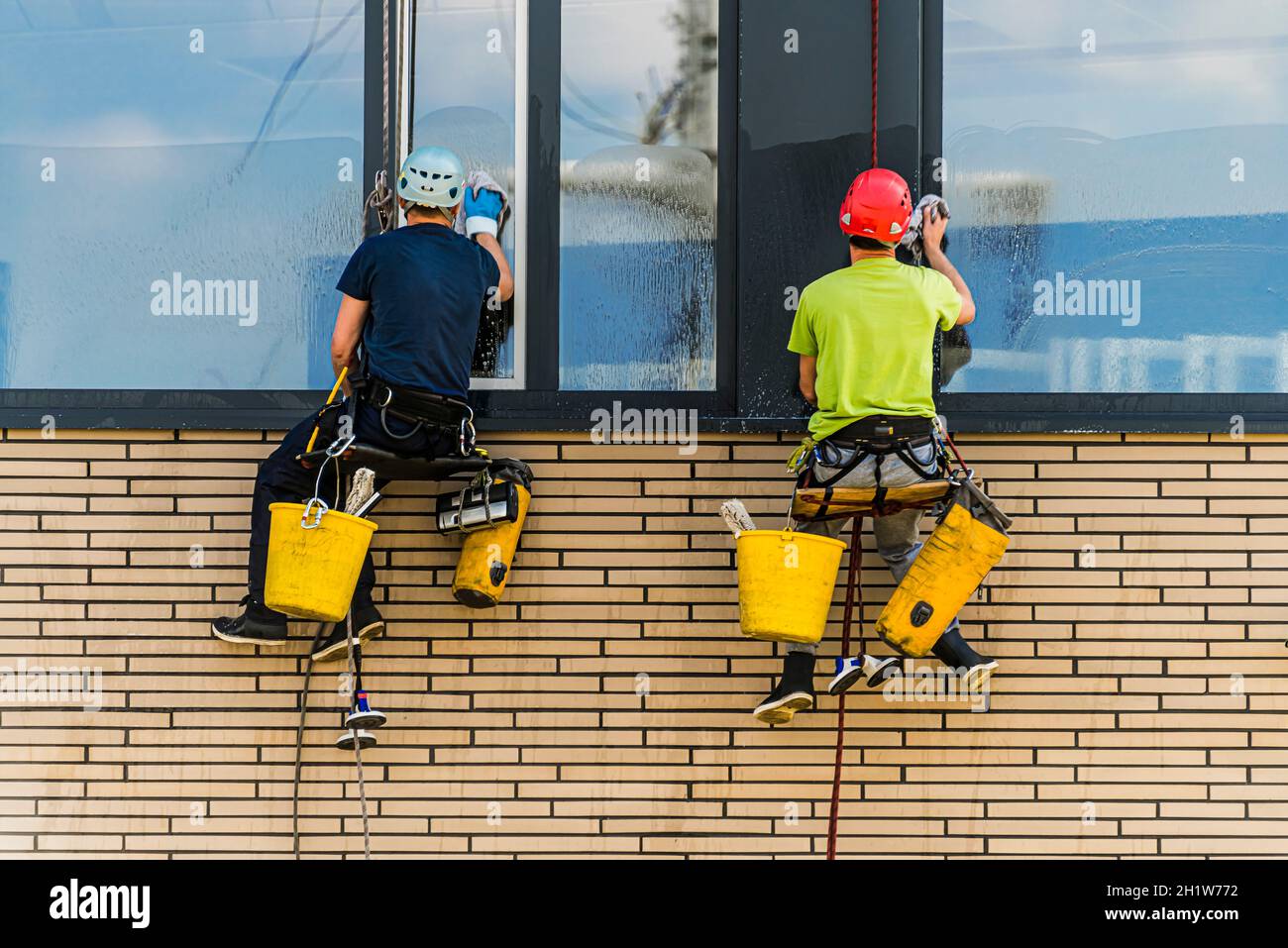 Two men cleaning windows on an office building Stock Photo - Alamy