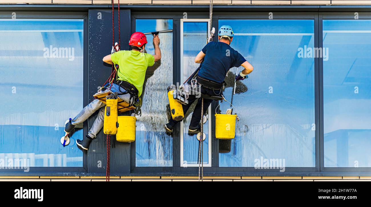 Two men cleaning windows on an office building Stock Photo - Alamy