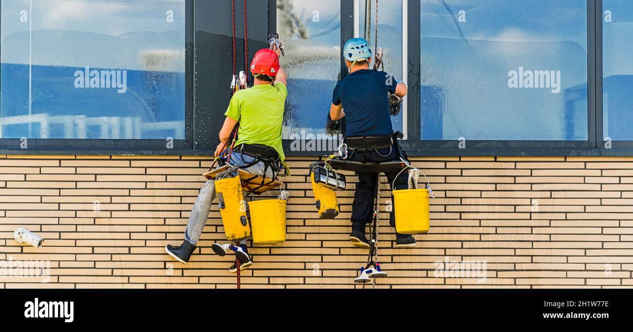 Two men cleaning windows on an office building Stock Photo - Alamy