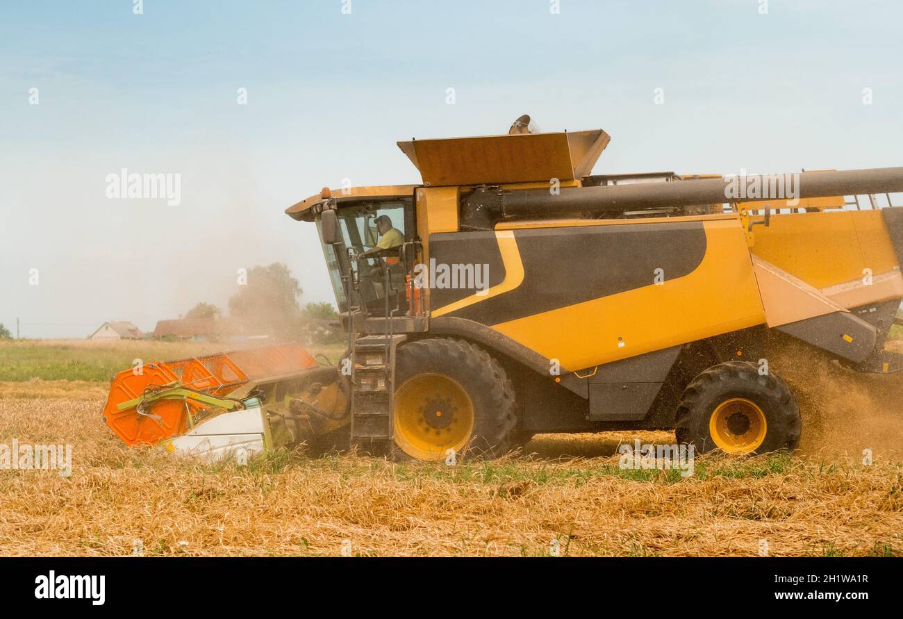 Man in combine harvesters with grain header, wide chaff spreader ...