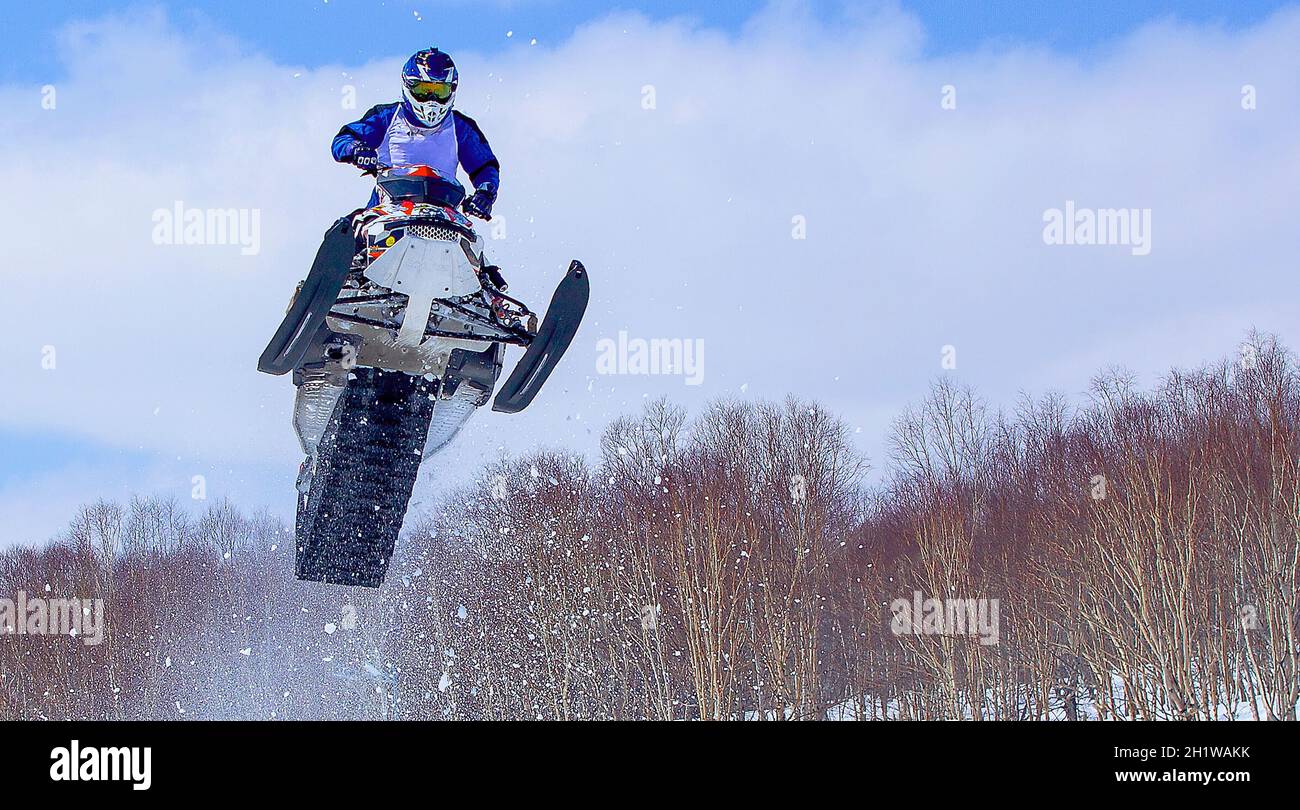 The Snowmobile in high jump above track. Selective focus Stock Photo ...