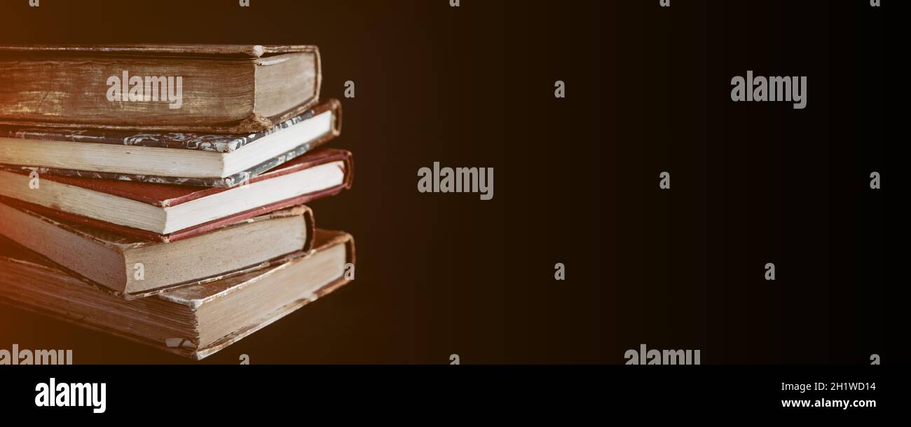Stack of old books isolated on black background banner Stock Photo - Alamy