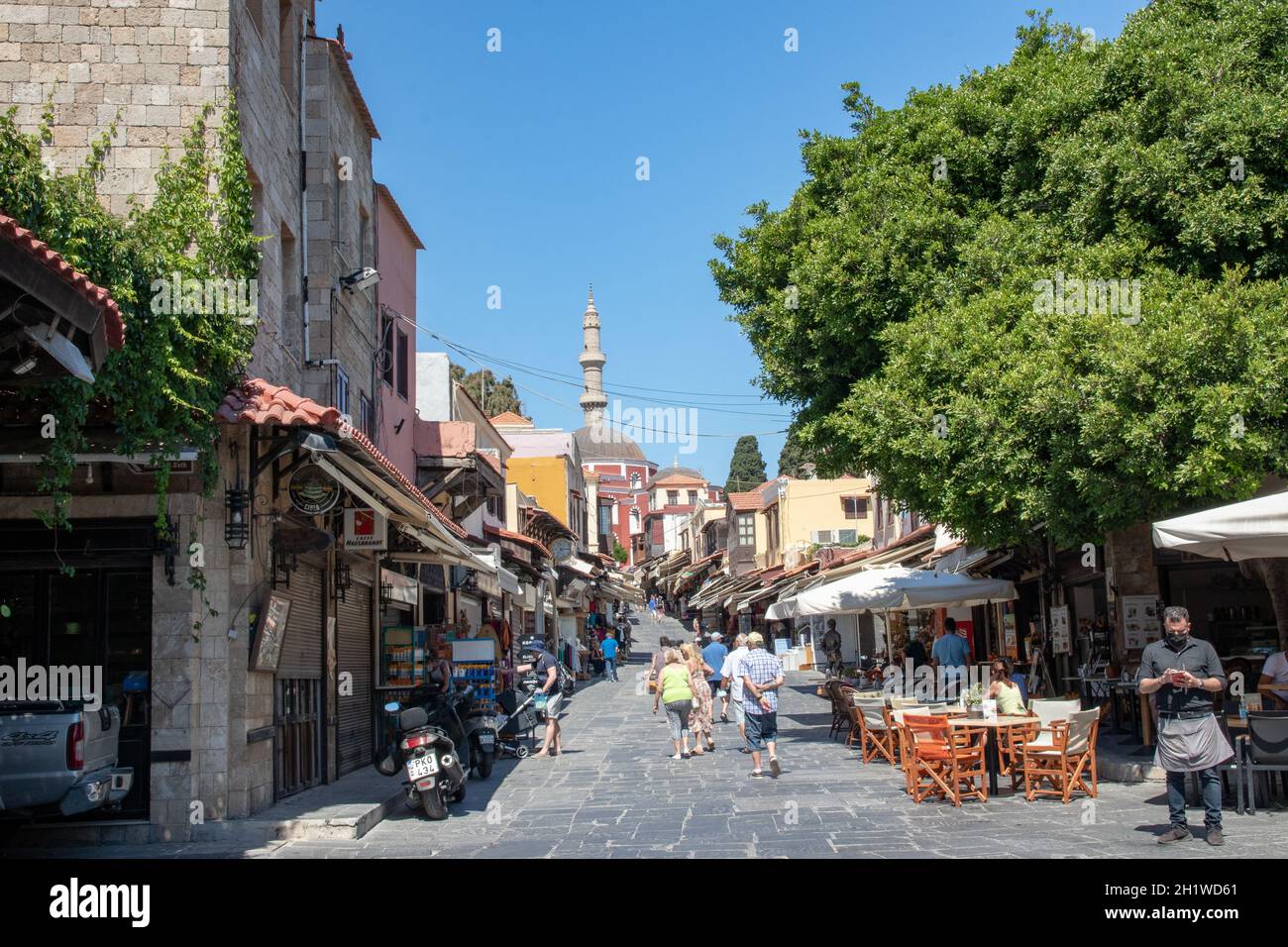 RHODES, Greece - JUN 07, 2021. Tourists walk along the shops of the ...