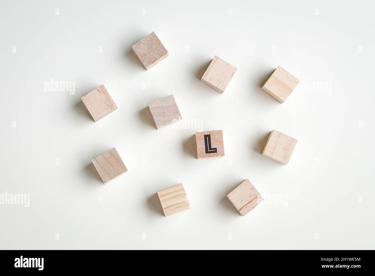 Wood cubes on white background with one L letter on one of the cubes ...