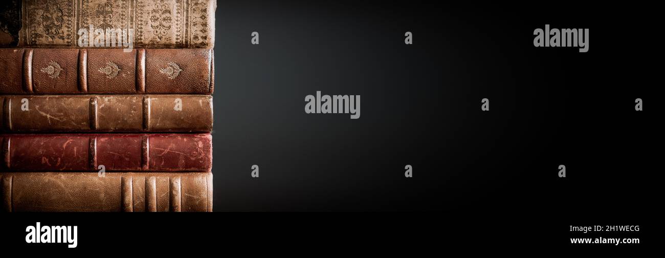 Stack of old books isolated on black background banner Stock Photo - Alamy