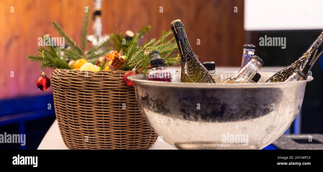 Wine in glass bottles is cooled in a metal bucket. Tasting of alcoholic ...
