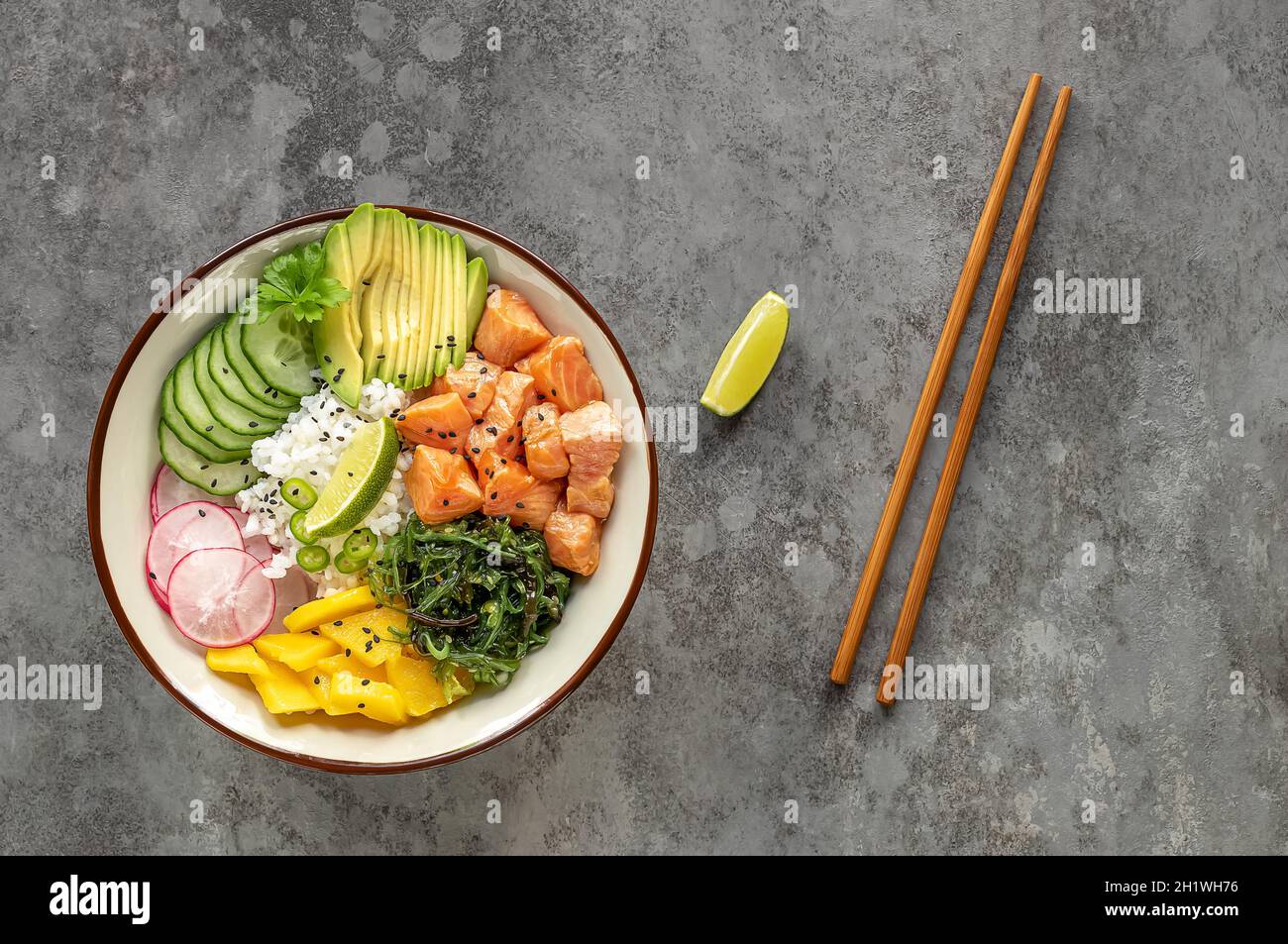 Hawaiian salmon fish poke bowl with rice, mango, radish, cucumber ...