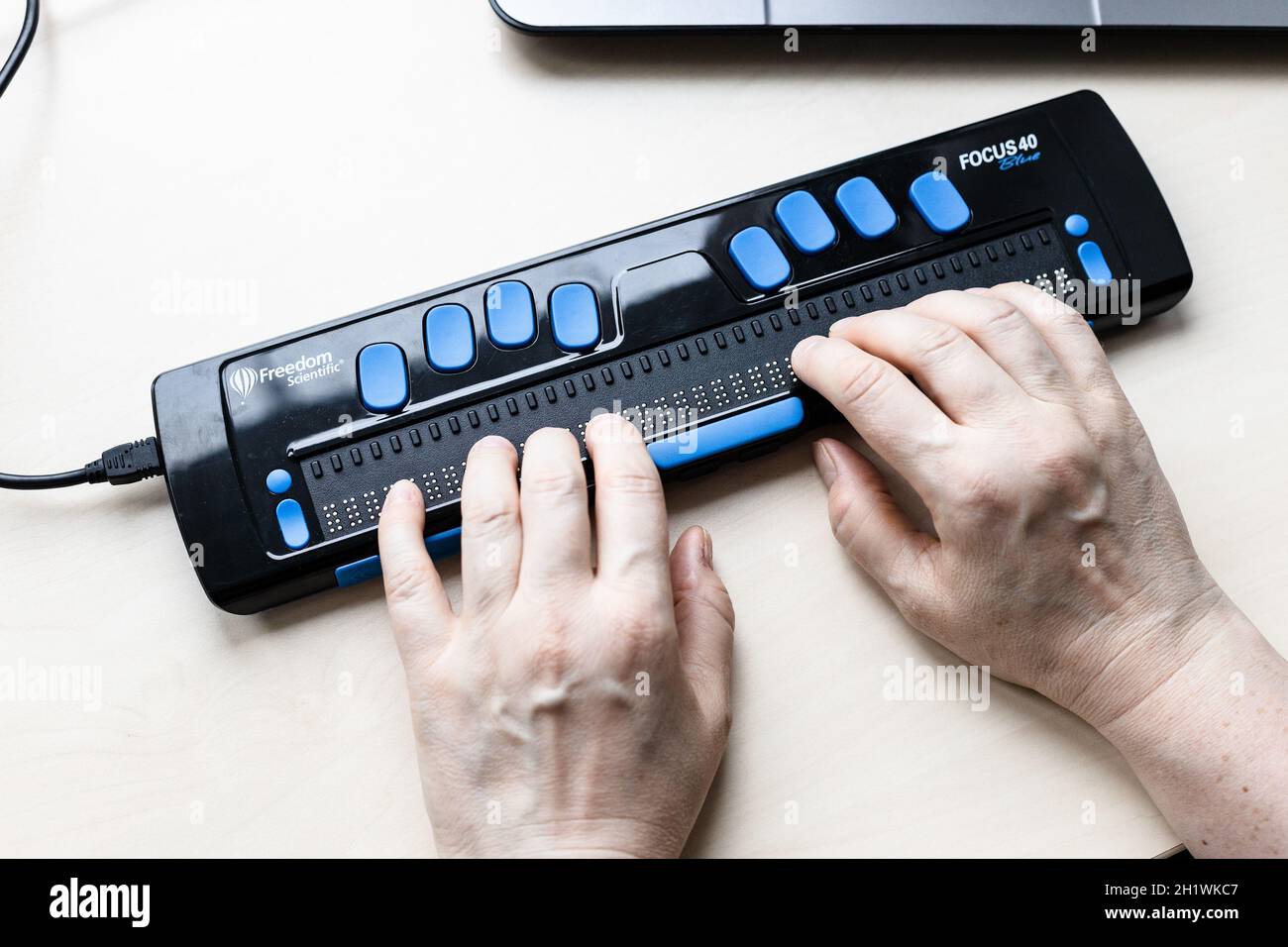 Moscow, Russia - June 5, 2021: female hands on Focus 40 Blue Braille ...