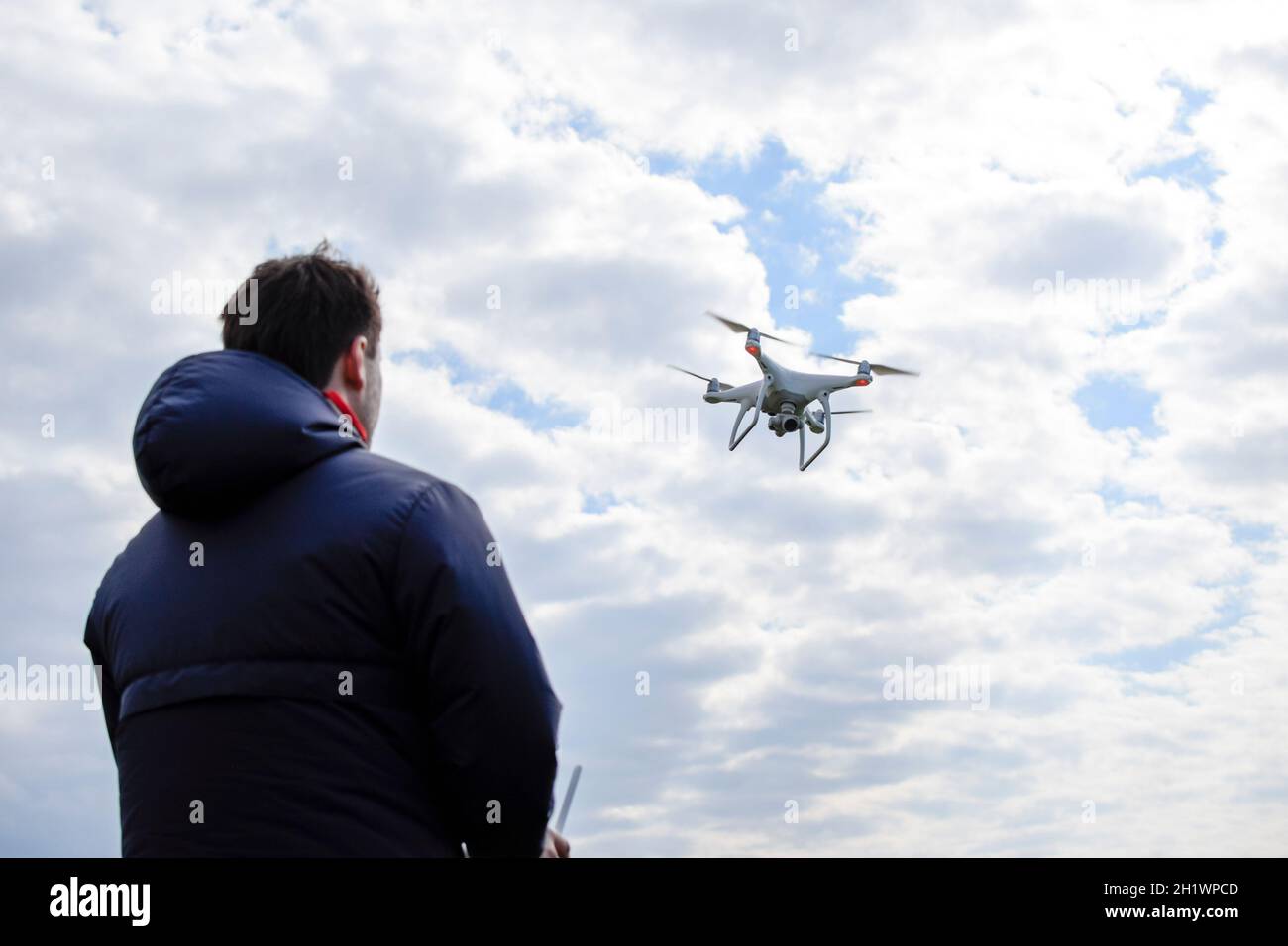 A man with a remote control in his hands. Controlling the flight of the ...