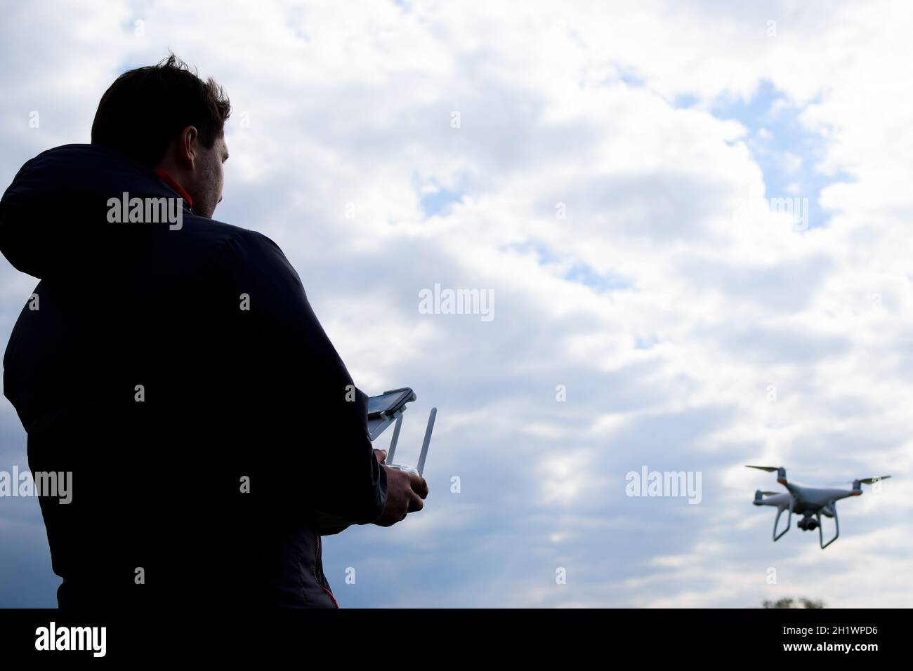 A man with a quadrocopter in his hands. White kvadrokopter prepare for ...