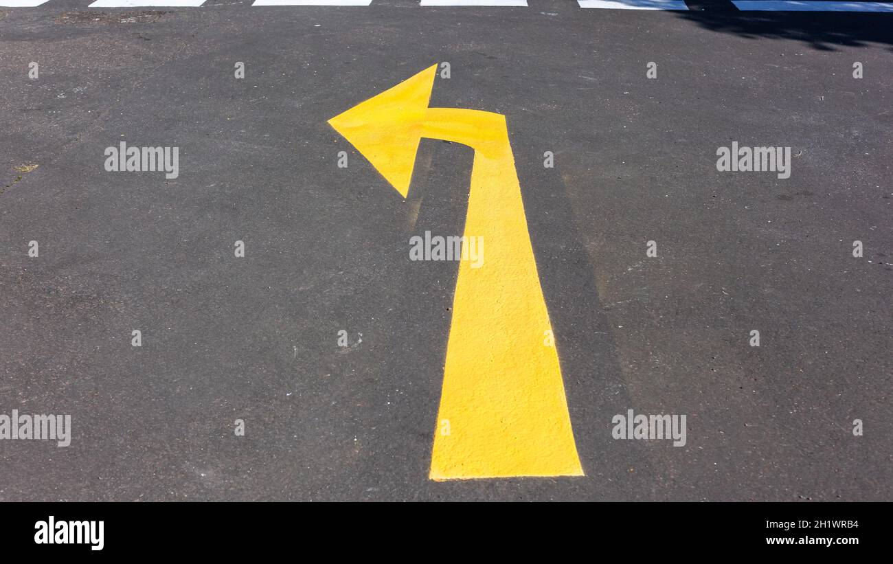 Road fresh yellow arrow sign for route direction on asphalt tarmac at ...