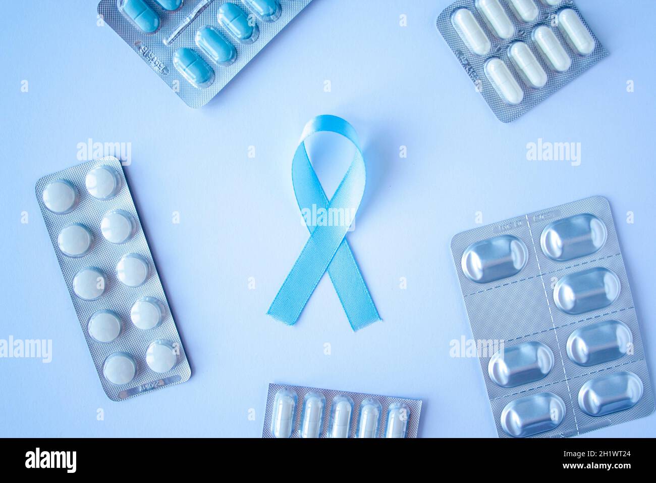 Blue ribbon symbol of prostate cancer with many pills and drugs ...