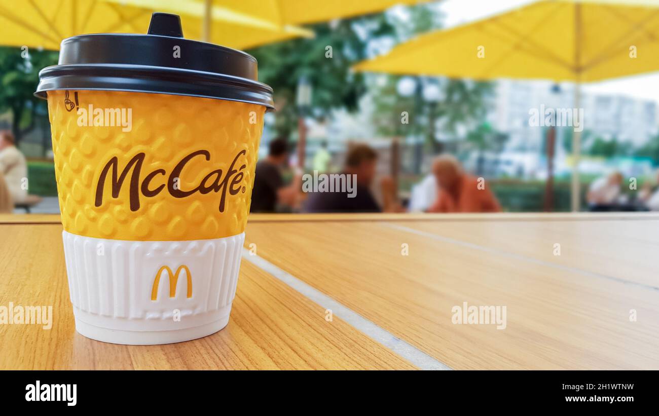 McCafe menu at McDonalds restaurant. Yellow cup of coffee on a table ...