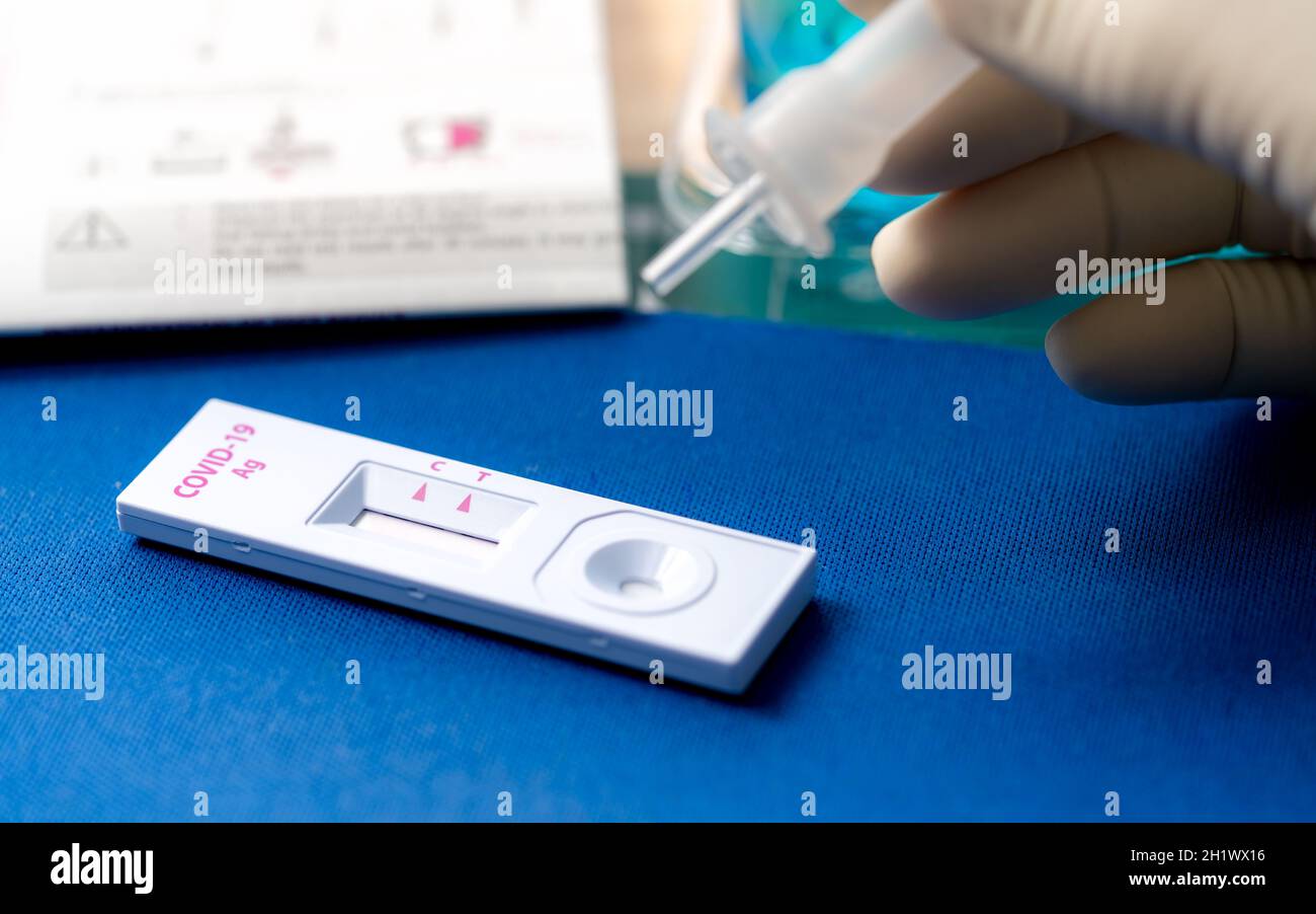 Hand holding sample tube and drops in the test device of covid 19 ...