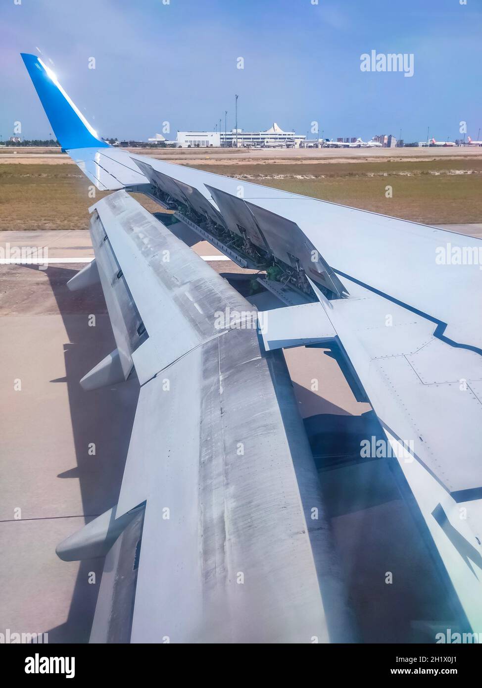 An airplane window view of wing and flaps after landing. The plane ...
