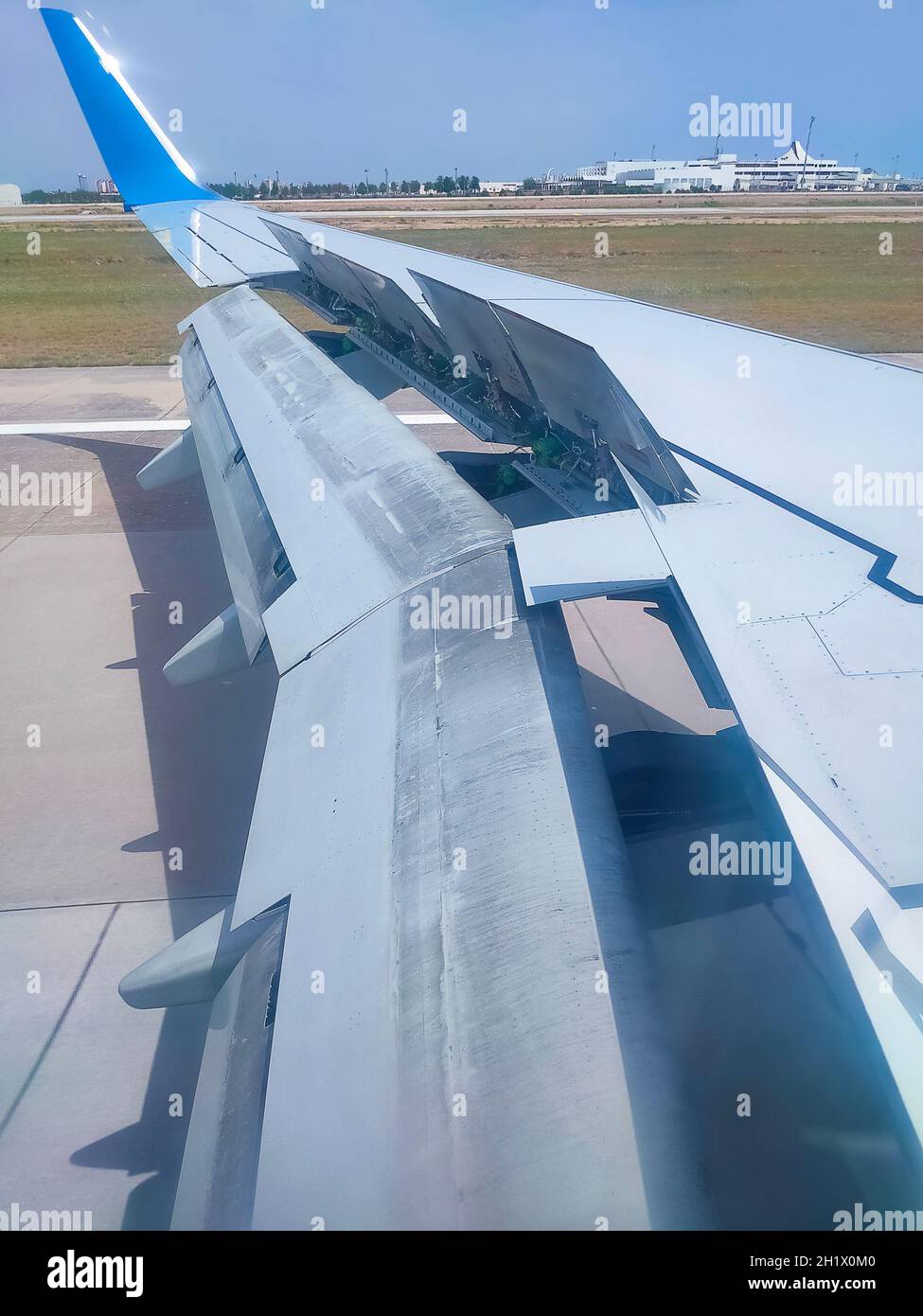 An airplane window view of wing and flaps after landing. The plane ...