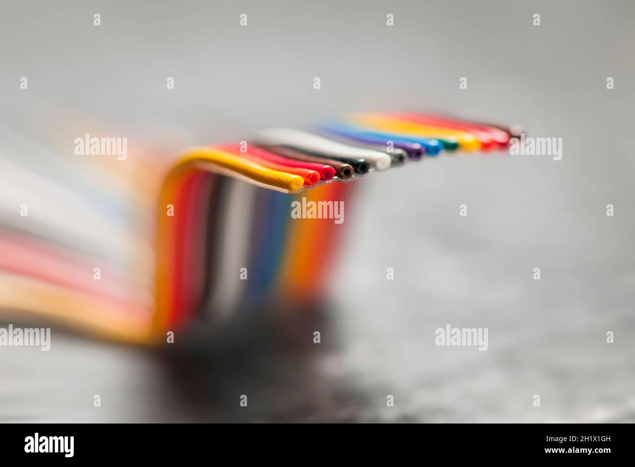 Close up of a short, bent and colorful computer ribbon cable on a rough ...