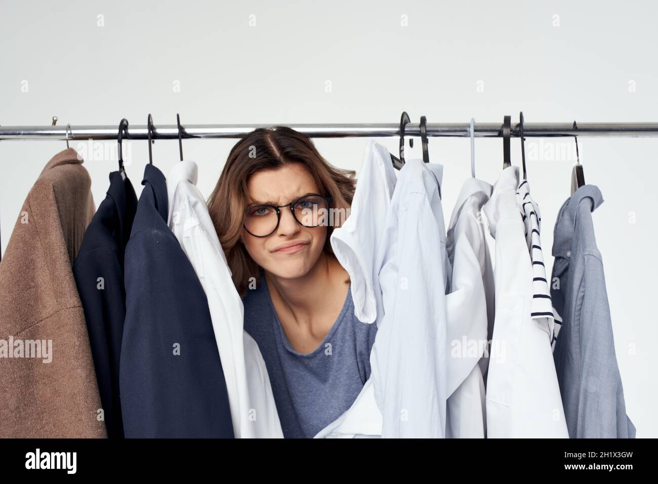 pretty woman selection of clothes near the wardrobe light background ...