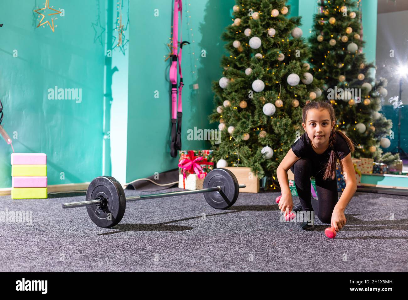 Merry Christmas and a happy new year. Little girl workout at home in ...