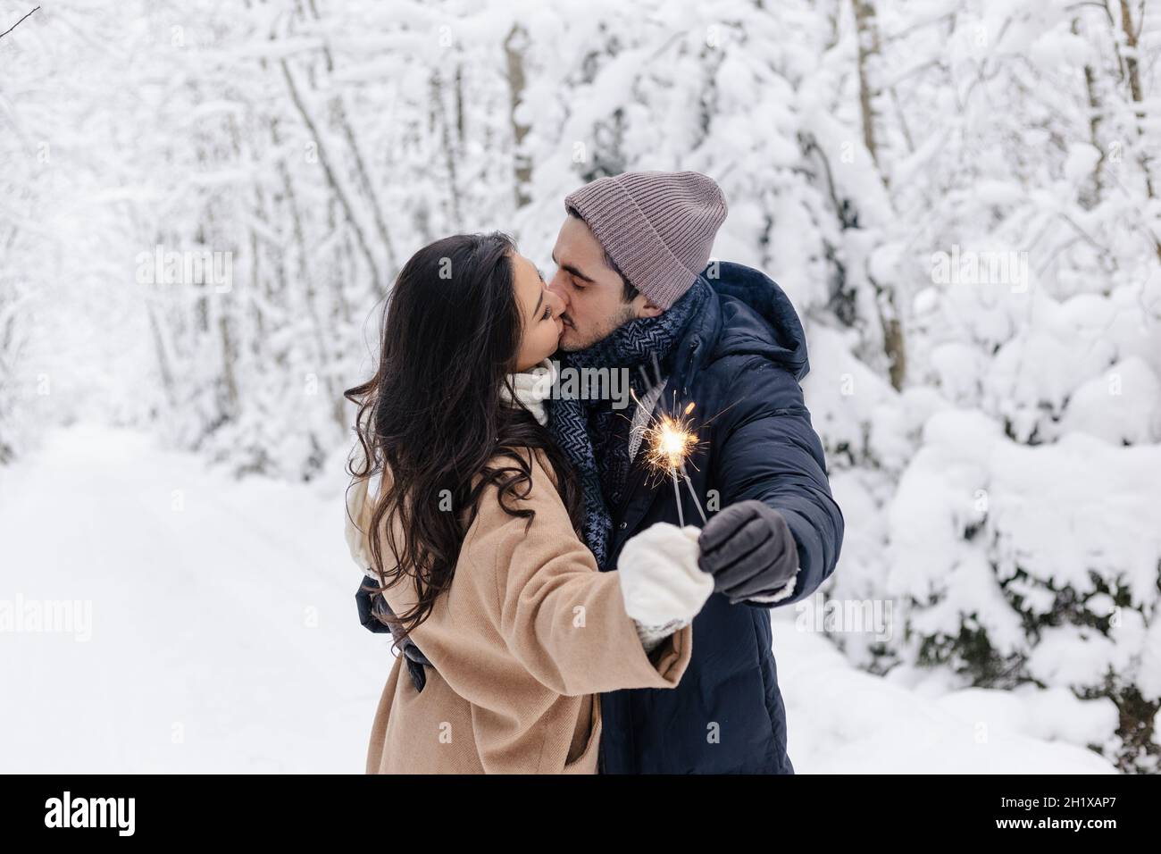 Couple Love Story in Snow Forest Kissing and Holding Sparklers. Couple ...