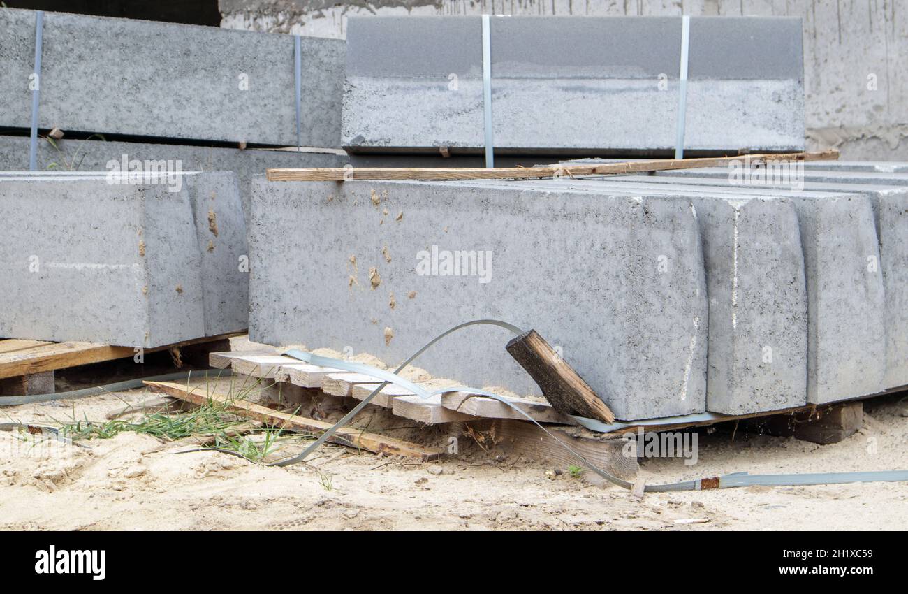 Faceted granite curbs on a pallet. Smooth porcelain stoneware products ...