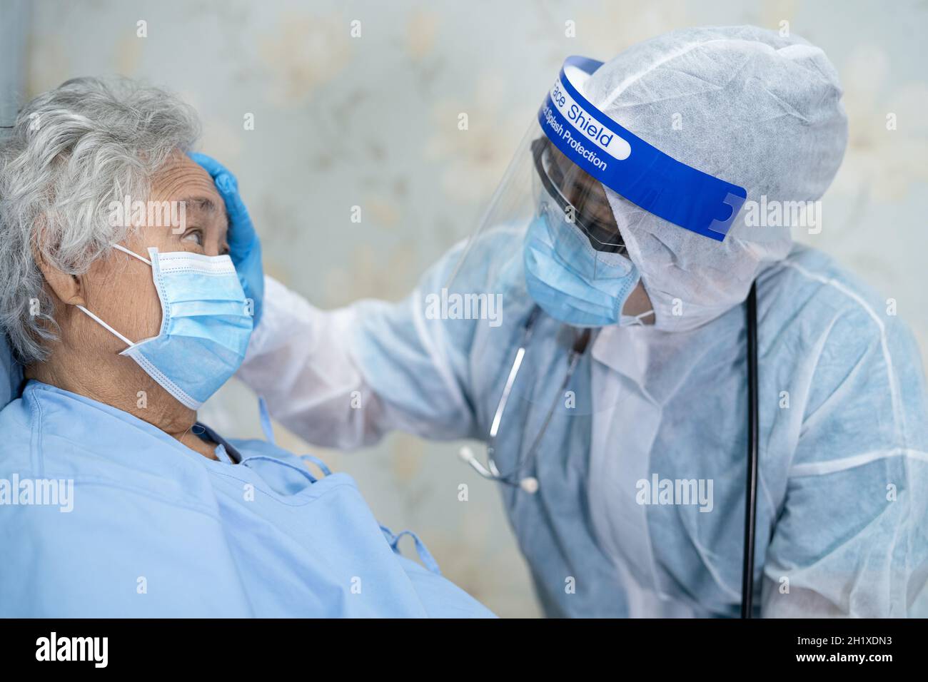 Asian doctor wearing face shield and PPE suit new normal to check ...