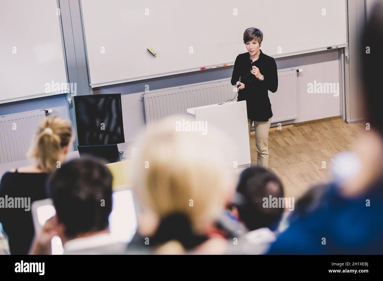 Speaker giving presentation in lecture hall at university. Participants ...