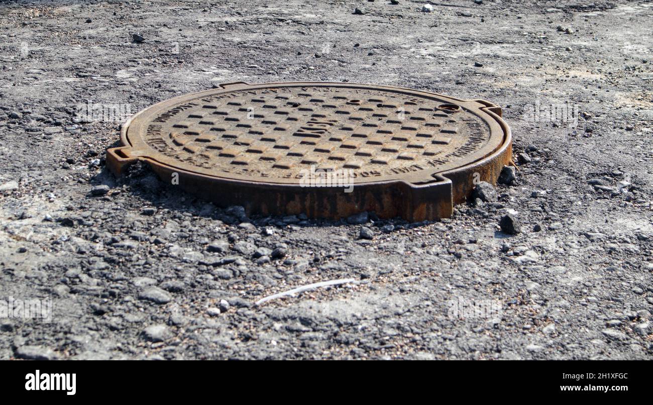 Metal manhole on the road when paving new asphalt. Renovation work. A ...