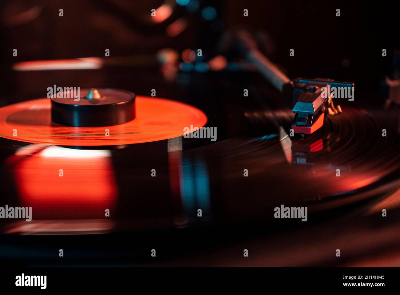 Needle detail on vinyl record on turntable, low light image with ...