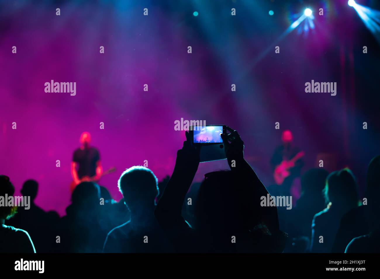 Crowd at concert - Cheering crowd in bright colorful stage lights Stock ...