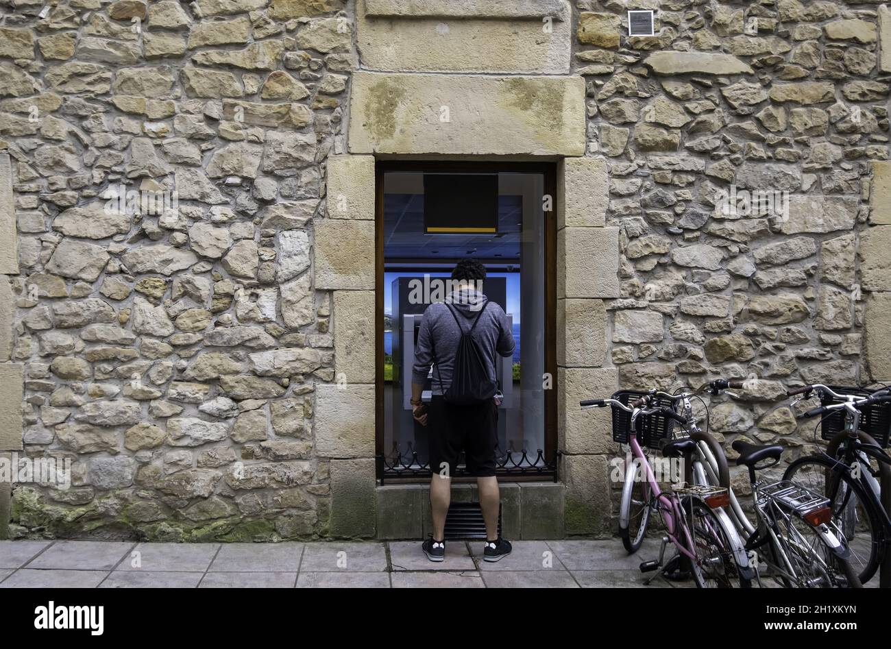 Detail of young man taking money out of a bank, cash Stock Photo - Alamy