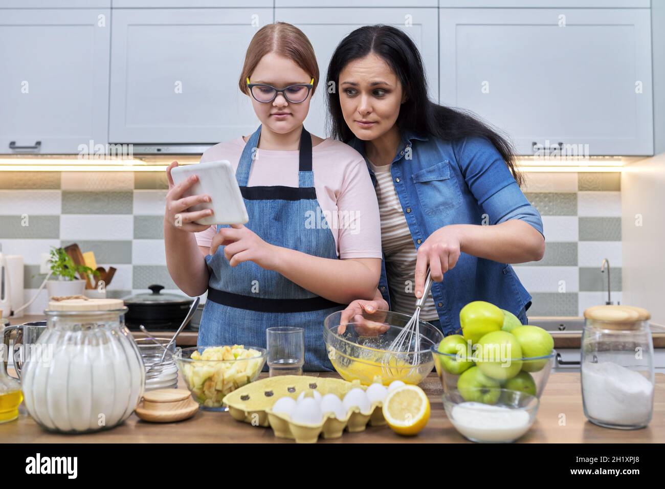 Mom and teenage daughter preparing apple pie together Stock Photo - Alamy