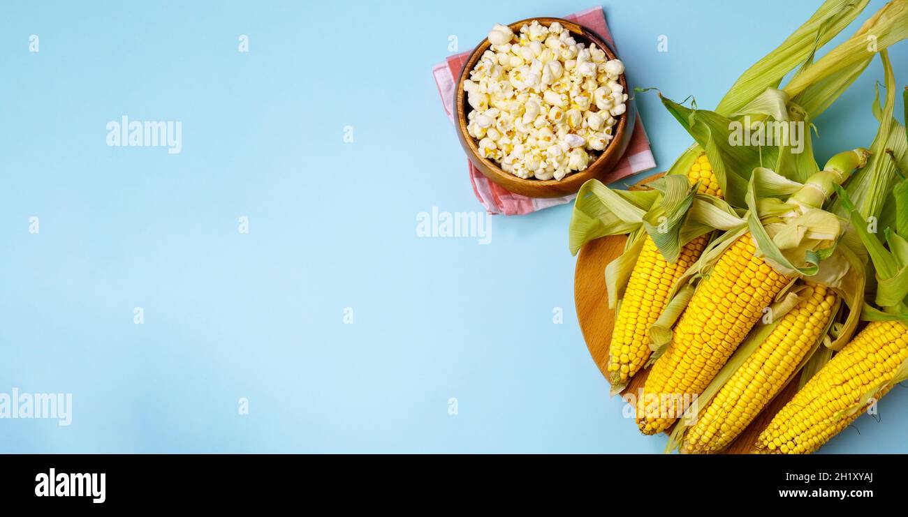 Fresh uncooked corncob, popcorn. Healthy summer food concept. Blue ...