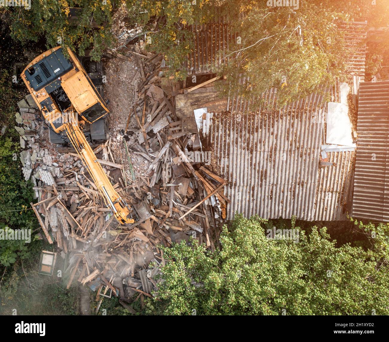 Destruction of old house by excavator. Bucket of excavator breaks ...