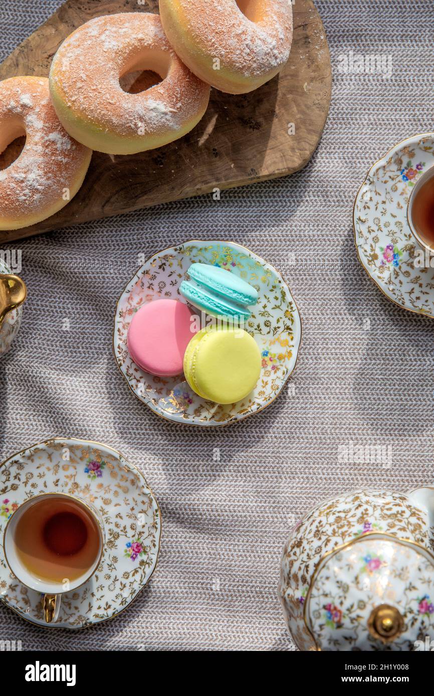 Cup of tea and macarons on diner table, antique tea pot set and ...