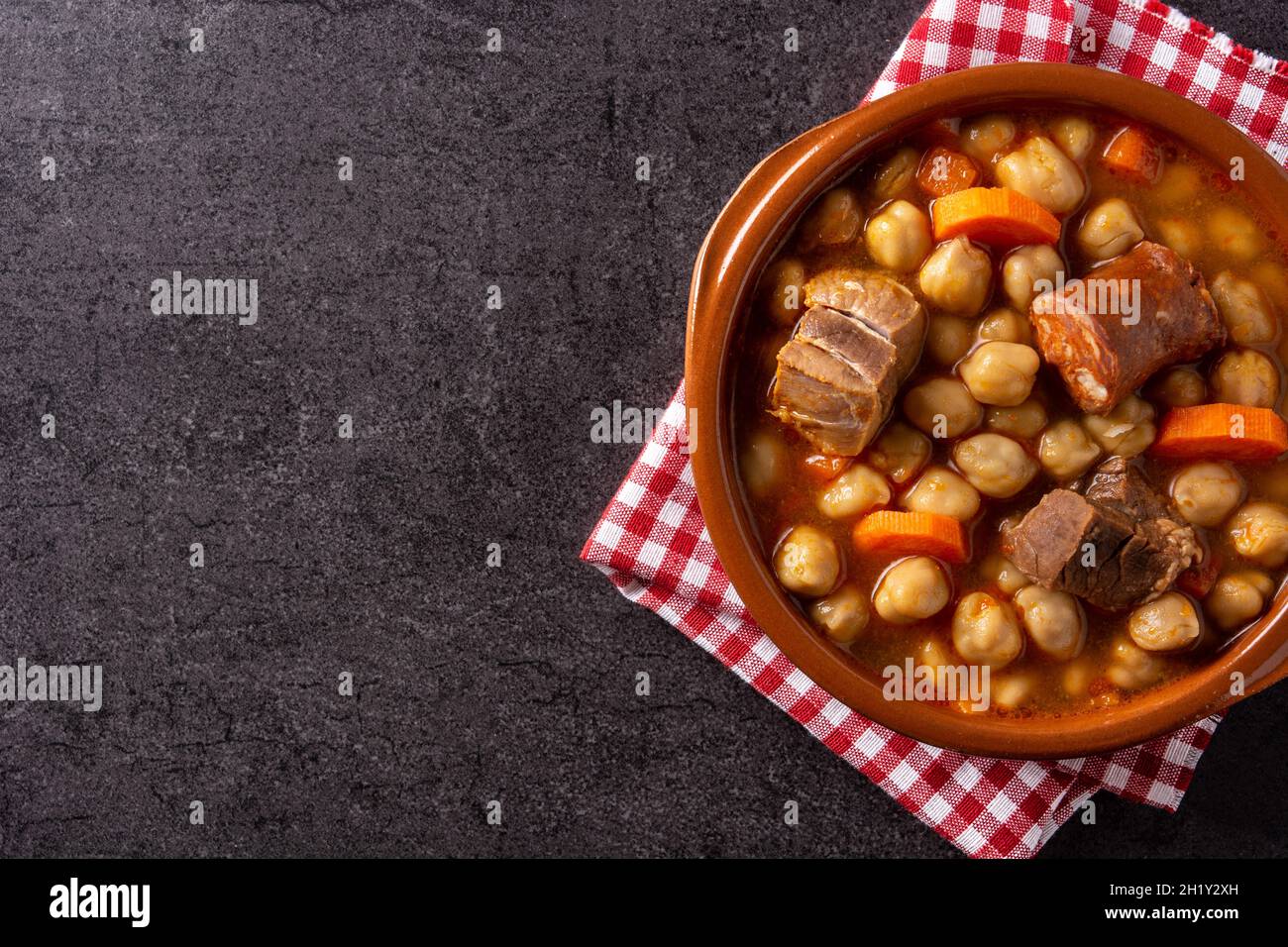 Traditional Spanish cocido madrileño in bowl on black background Stock ...
