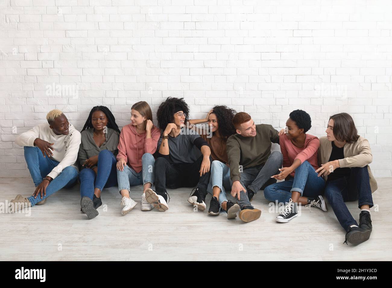 Multiracial millennials chilling together, sitting on floor Stock Photo ...