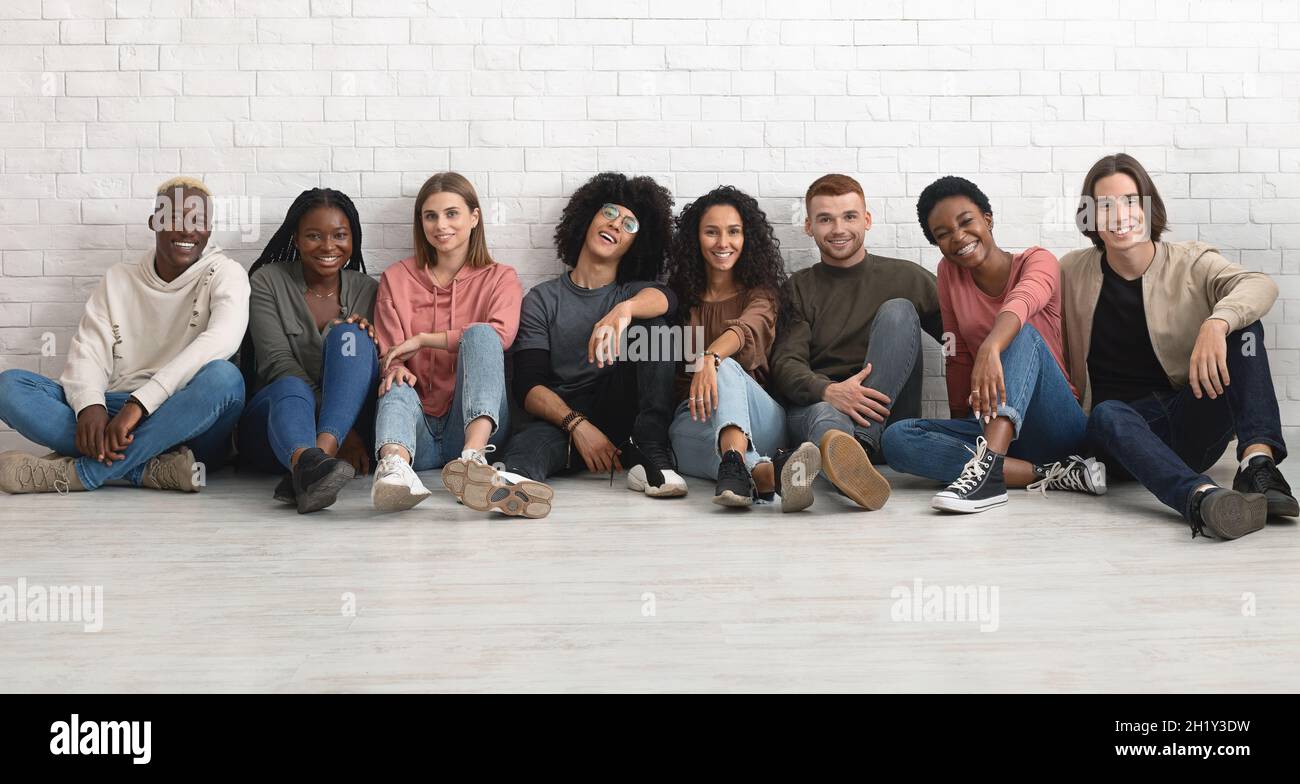 Carefree multiracial students chilling together on floor Stock Photo ...