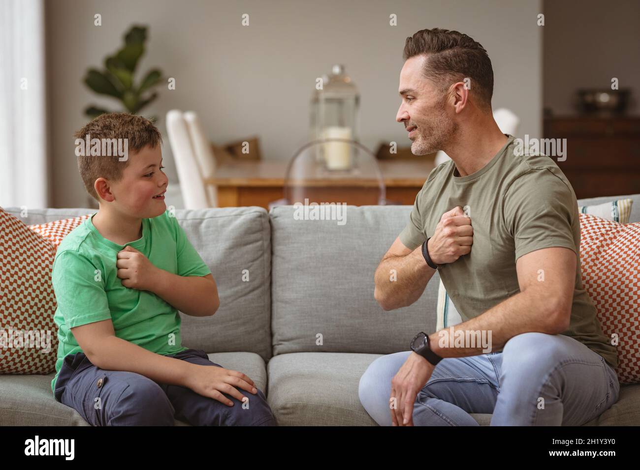Caucasian father and son communicating using sign language while ...