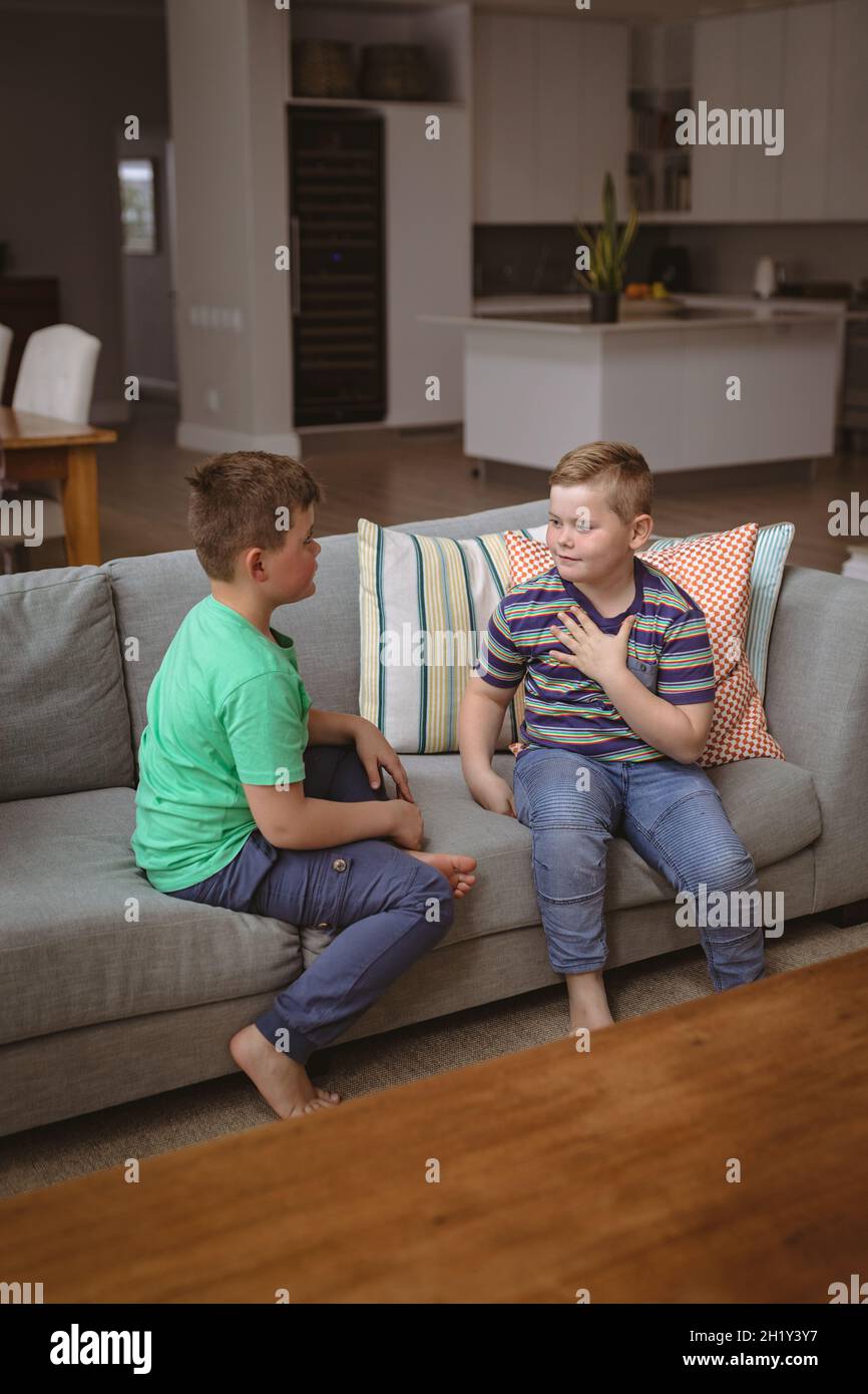 Two caucasian boys communicating using sign language while sitting on ...