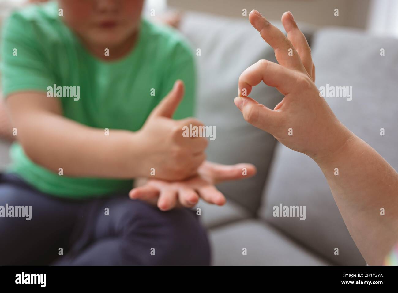 Two caucasian boys communicating using sign language while sitting on ...