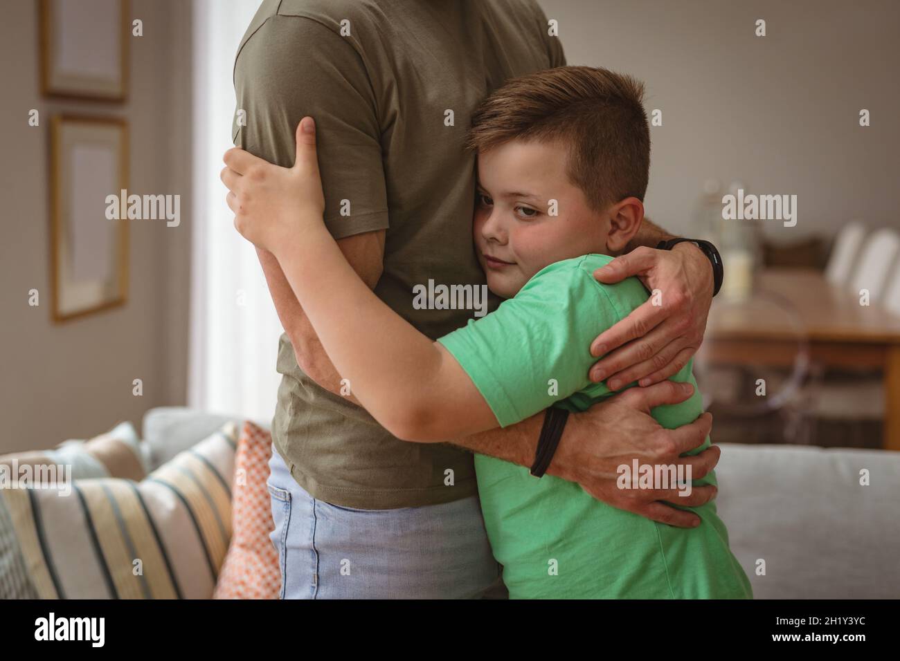 Caucasian boy hugging his father in the living room at home Stock Photo ...