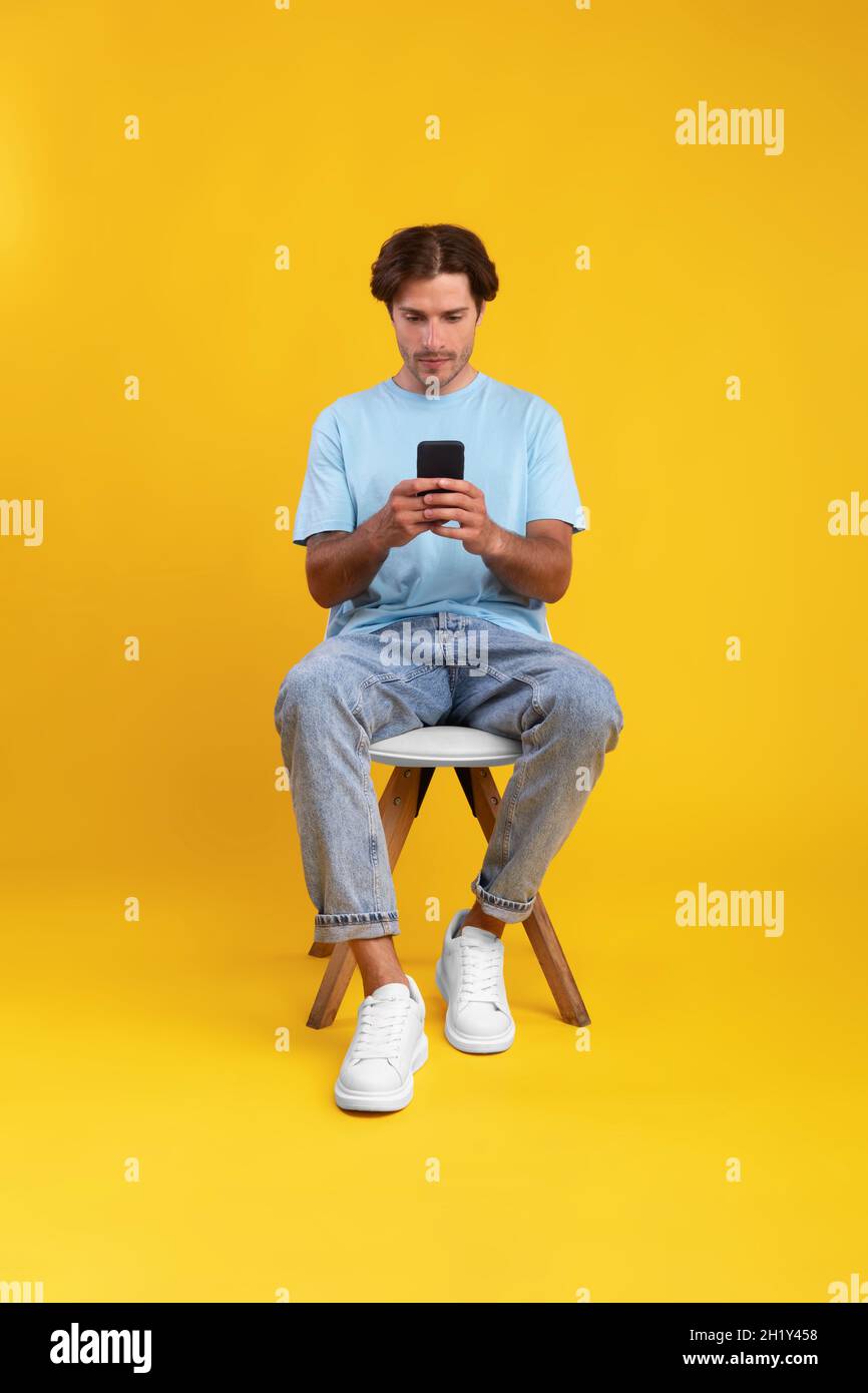 Man sitting on chair using cell hi-res stock photography and images - Alamy