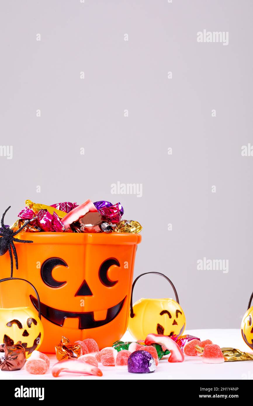 Composition of halloween bucket with trick or treat sweets, spider and ...