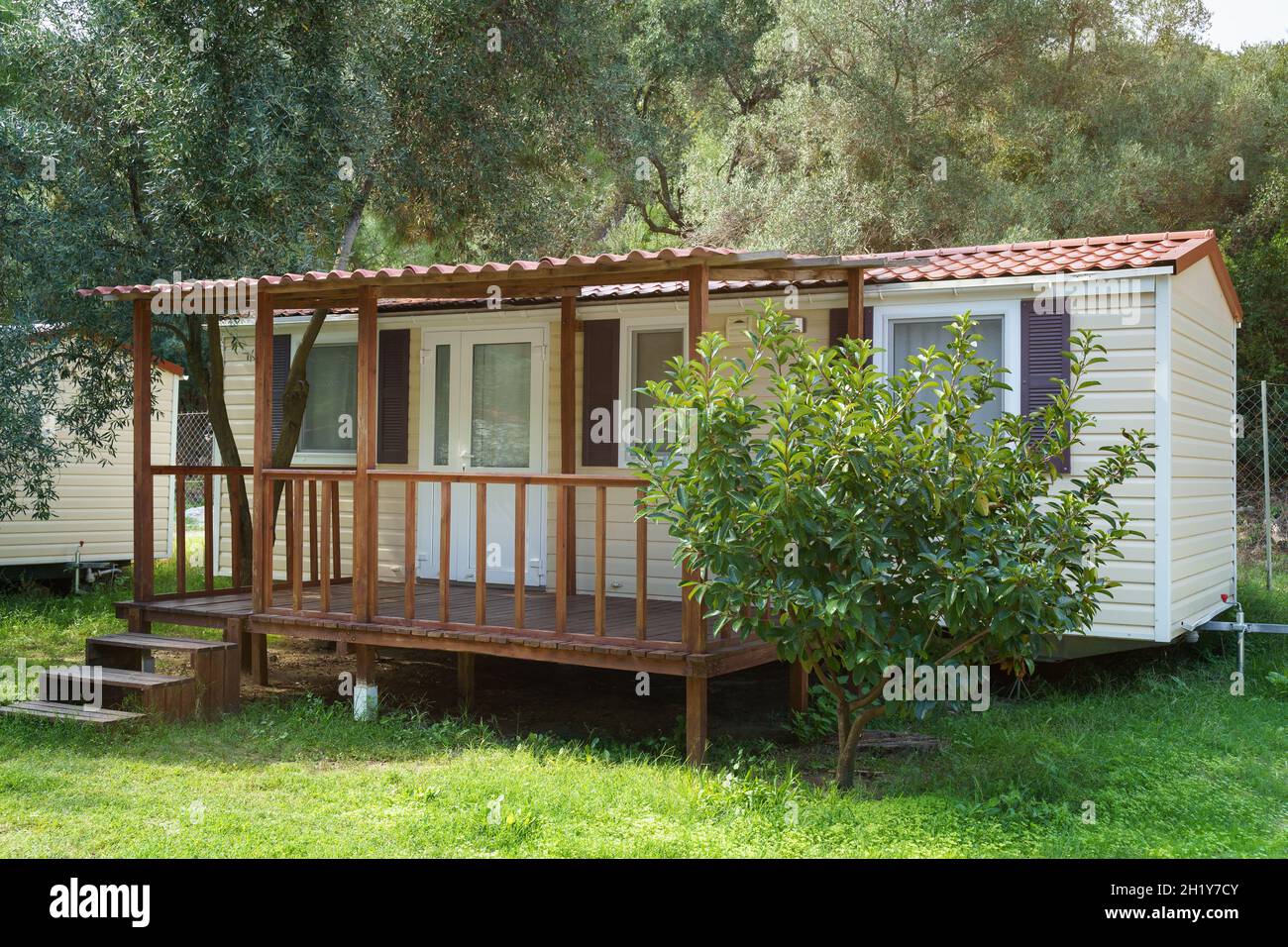 Vacation mobile houses on a campsite with trees around Stock Photo - Alamy