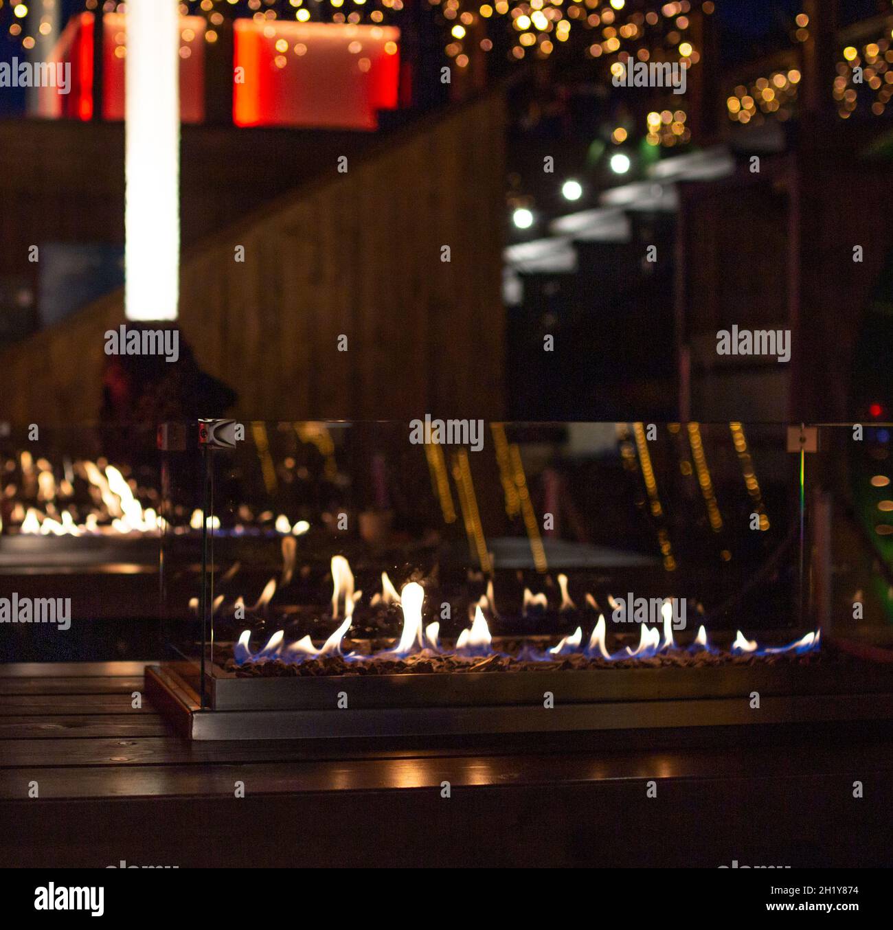 close up of fireplace with burning fire wood in cold winter night and ...