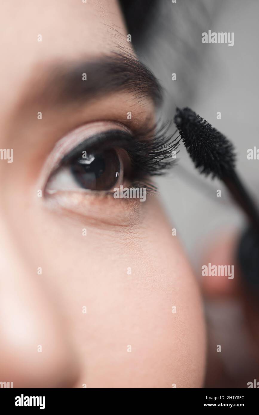 Woman applying mascara using eyelash wand Stock Photo - Alamy